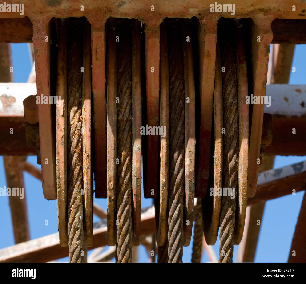 rusted metallic pulley with four rusted cables coming out of the pulley ...