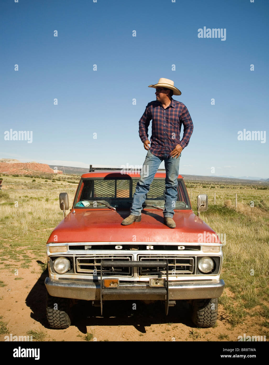 A portrait of a man standing on his red pickup truck Stock Photo - Alamy