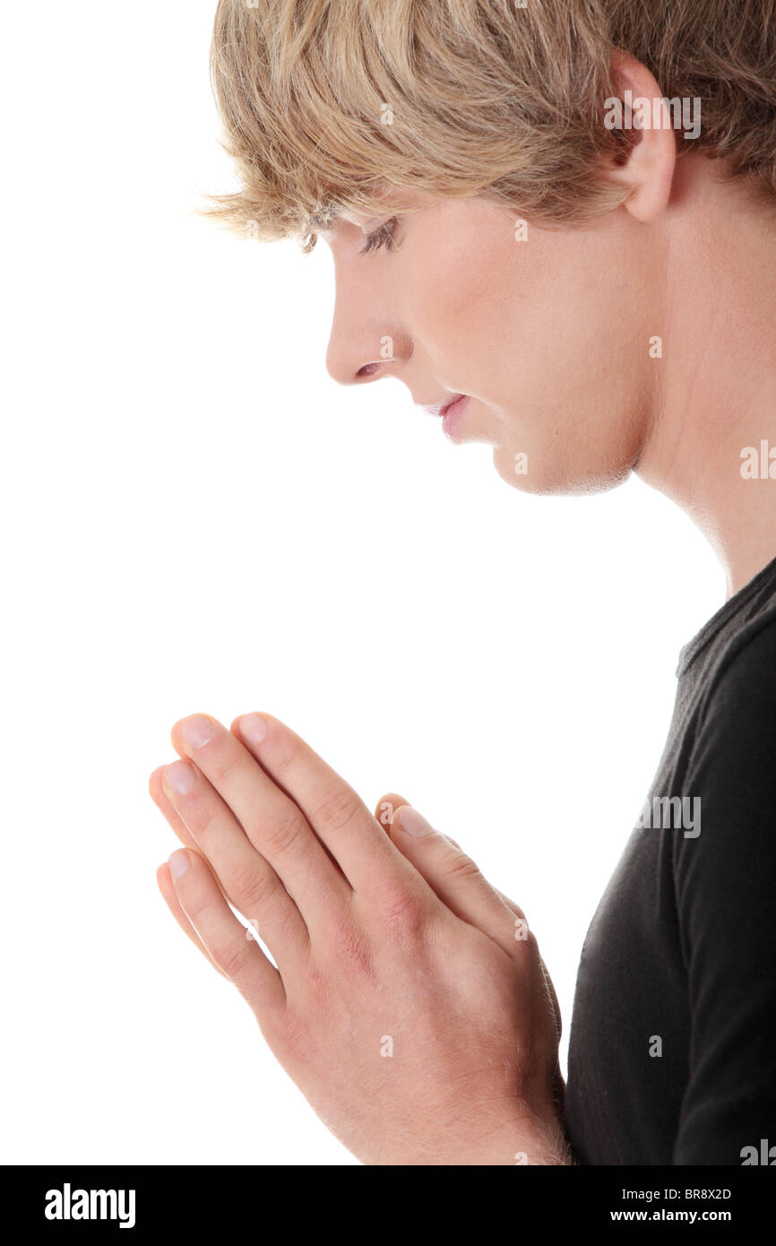 Young man with palms together, praying. Isolated on white background ...