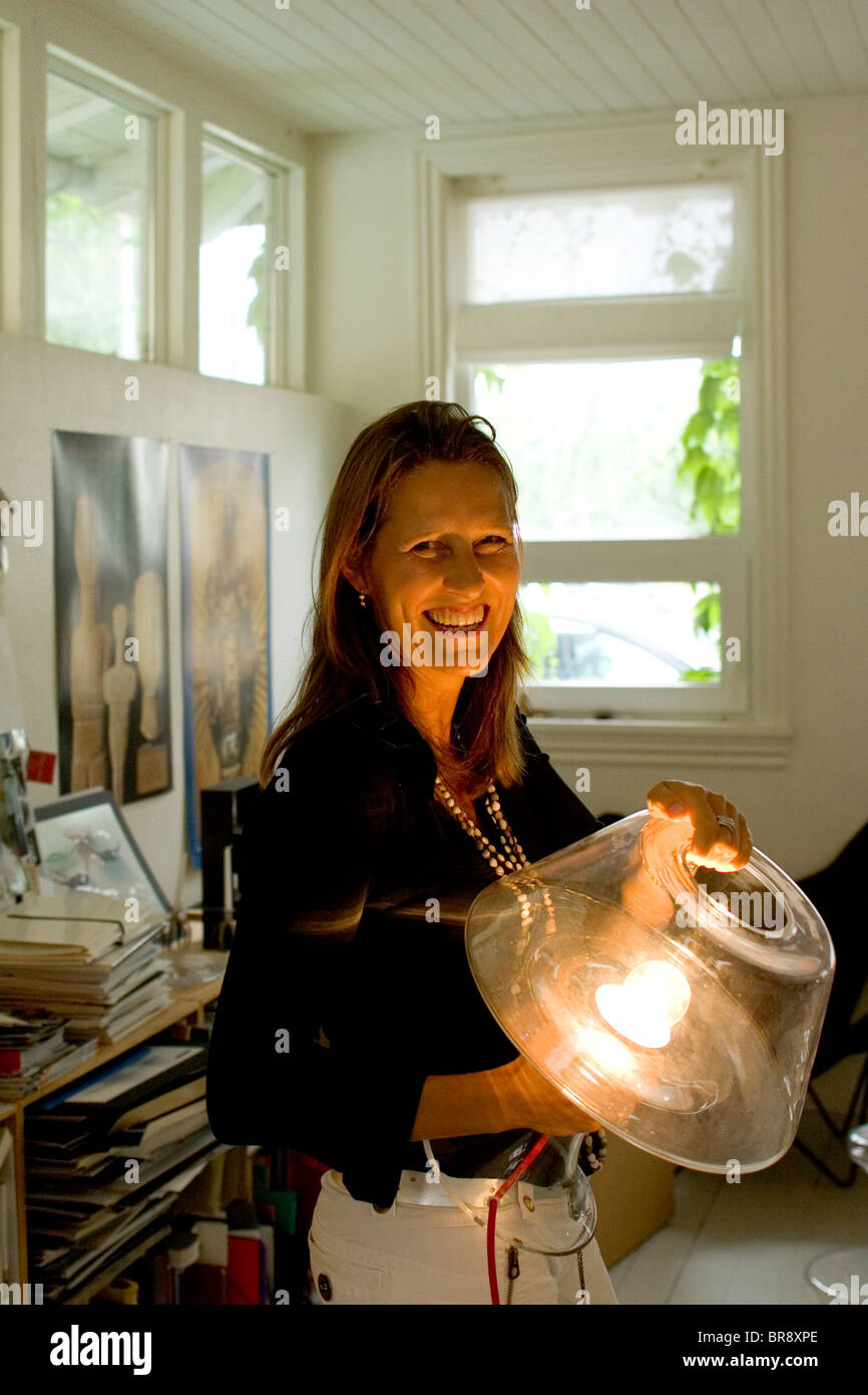 A woman poses with a lamp of her design in her studio in Copenhagen ...