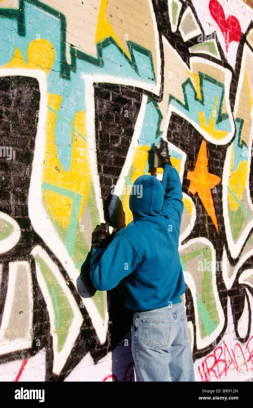 Hooded Graffiti Artist Spray Painting a Wall, NYC Stock Photo - Alamy