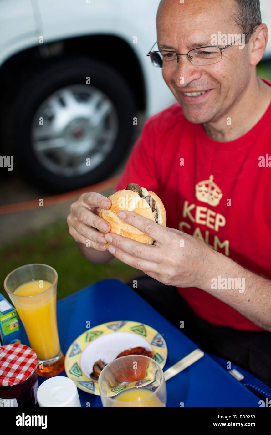 A family eating breakfast together outside there motorhome in a caravan ...