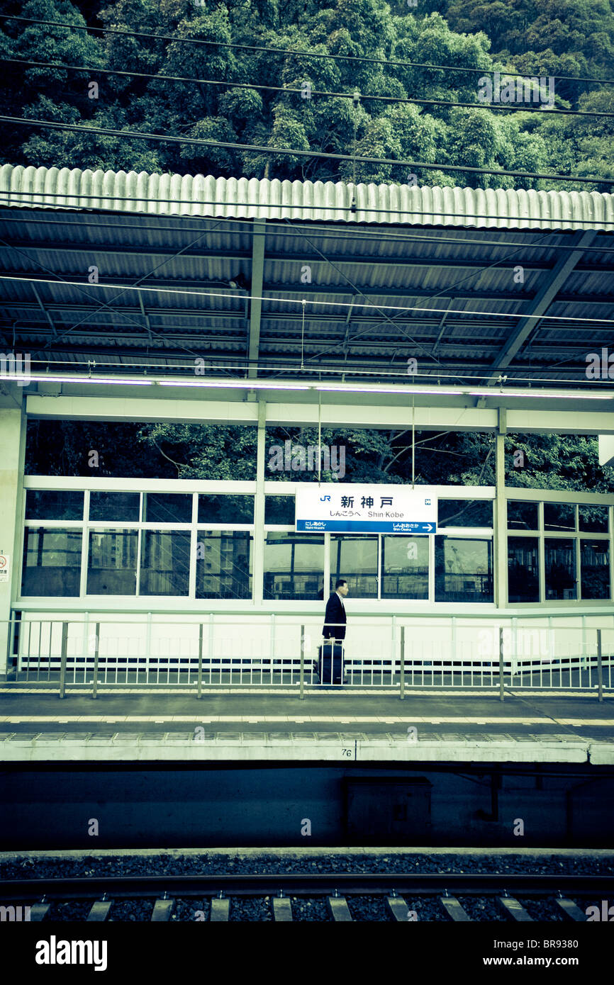 A lone businessman waits for a train at the Shin-Kobe station in Kobe ...