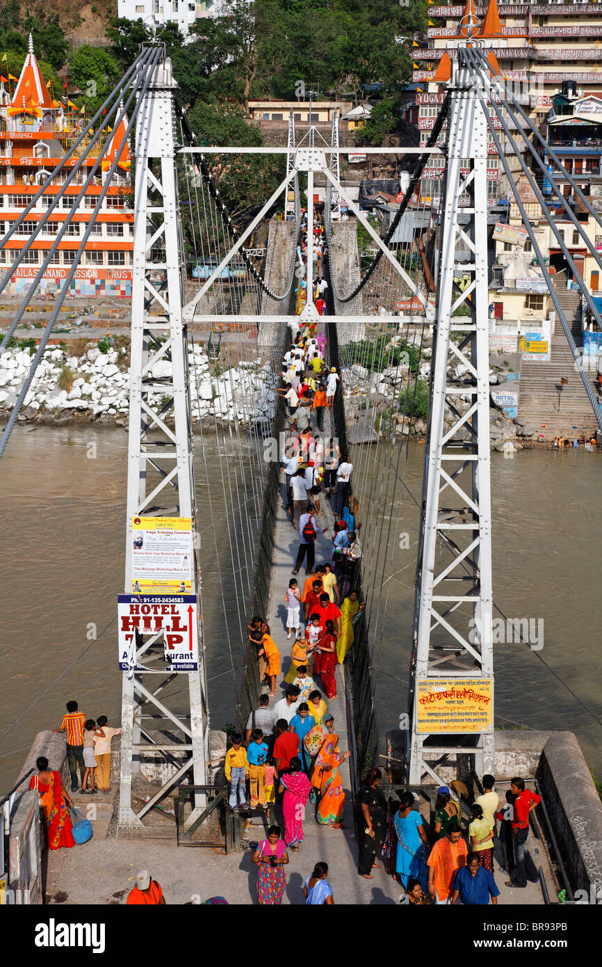 People crossing the Lakshmanjhula Bridge over the River Ganges ...