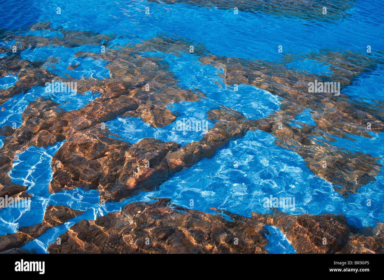 Rocks in blue water Stock Photo - Alamy