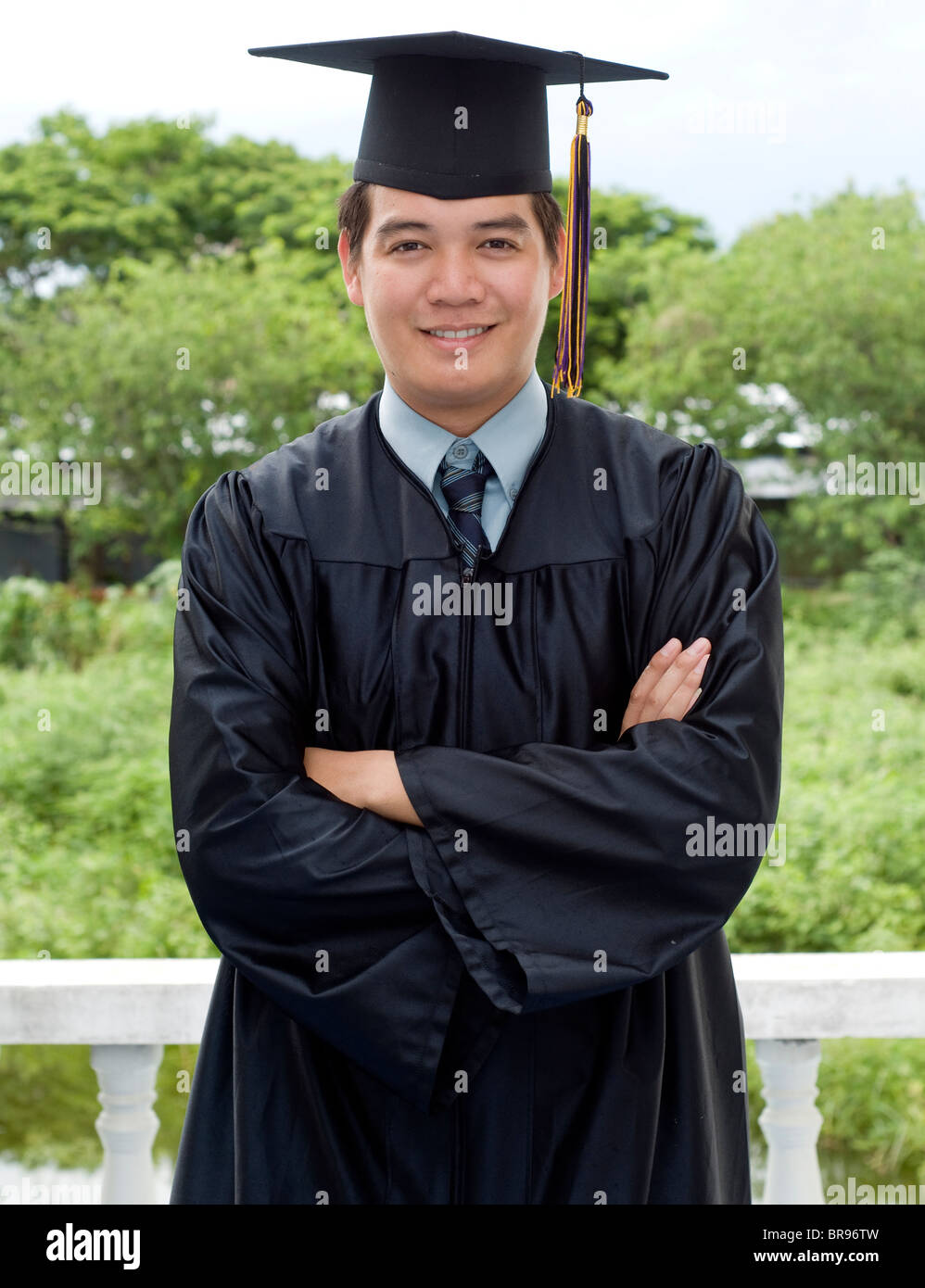 Young Asian man with graduation cap and gown Stock Photo - Alamy