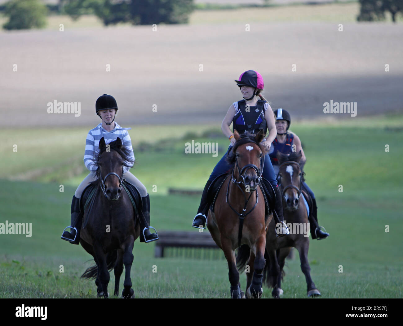Three riders galloping their horses towards the camera Stock Photo - Alamy
