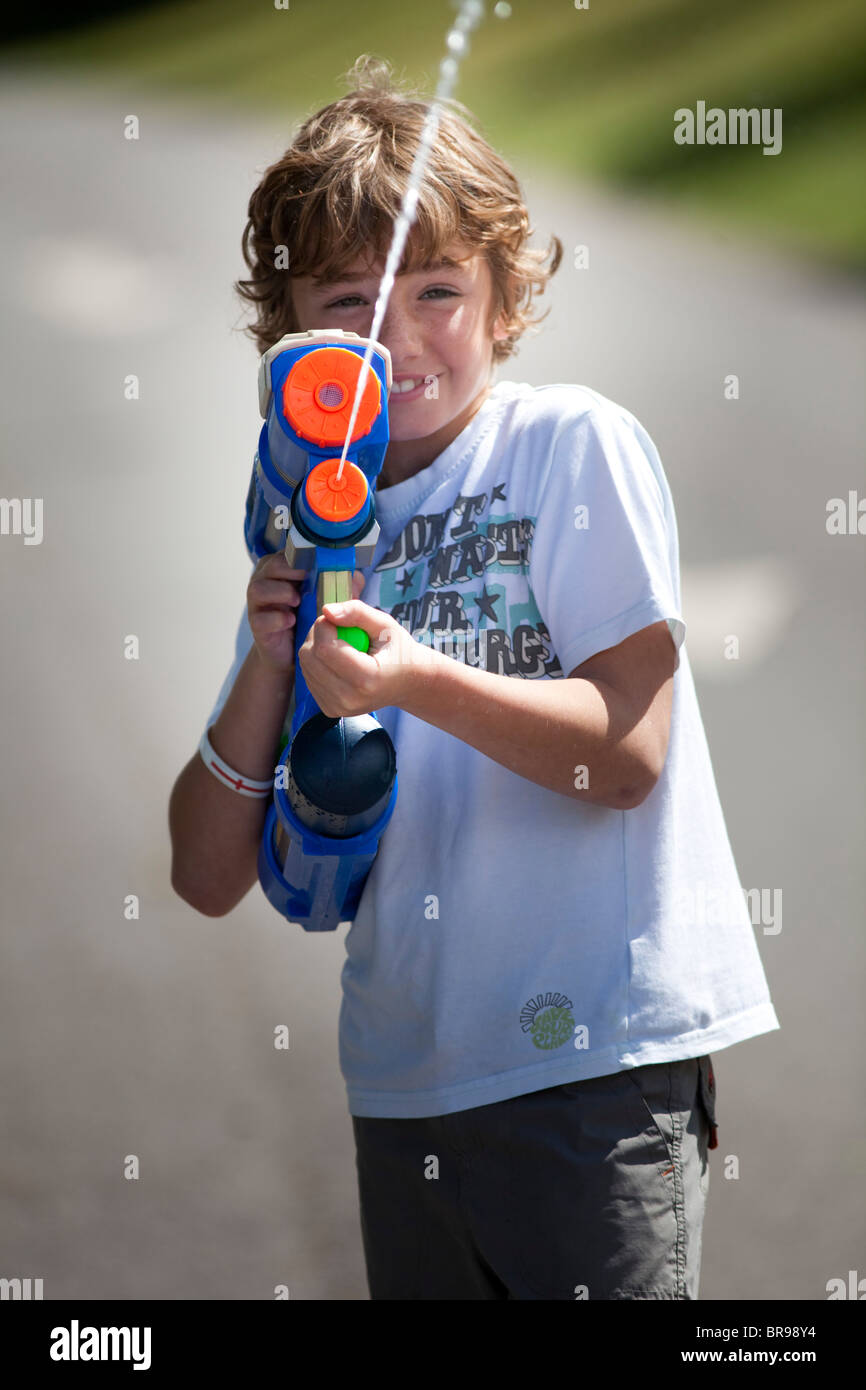 Boy shooting water pistol Stock Photo - Alamy