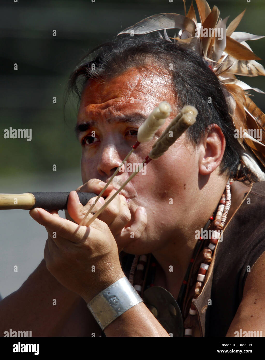 A Cherokee man, member of the Warriors of AniKituhwa group, blows a ...
