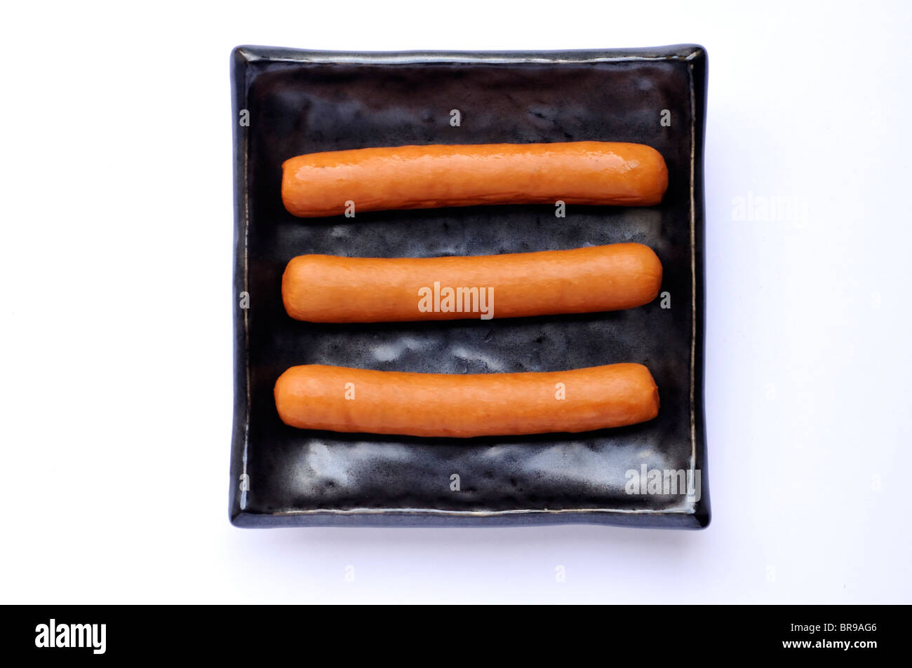 Three hot dogs on a square black plate Stock Photo - Alamy