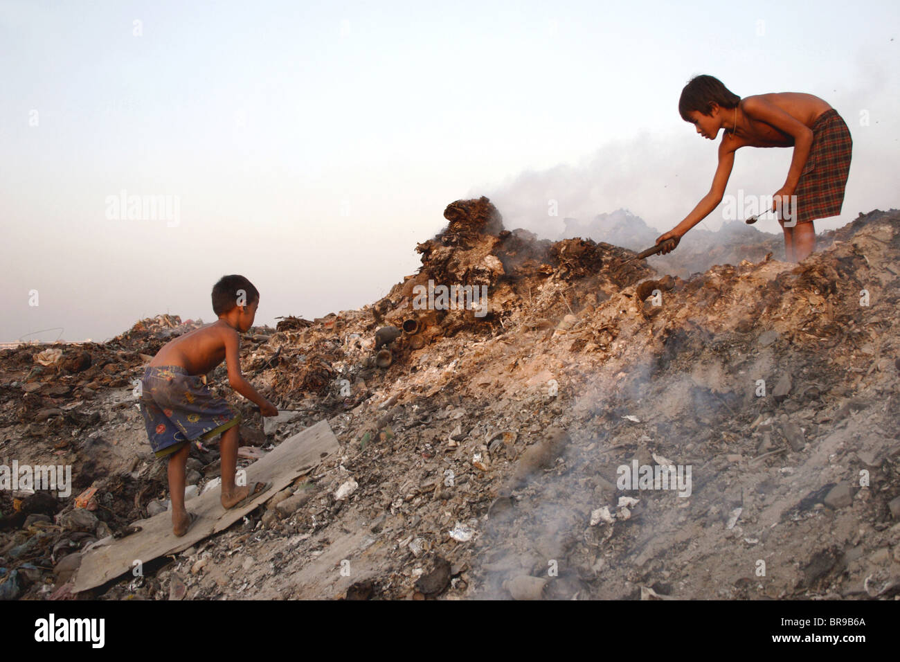 Child laborers use large gaffs, to collect plastic at the Stung ...