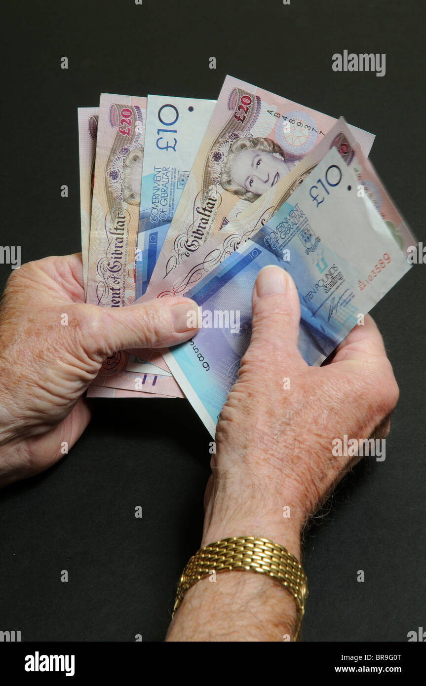 Man holding Government of Gibraltar issue issued ten and twenty pound ...