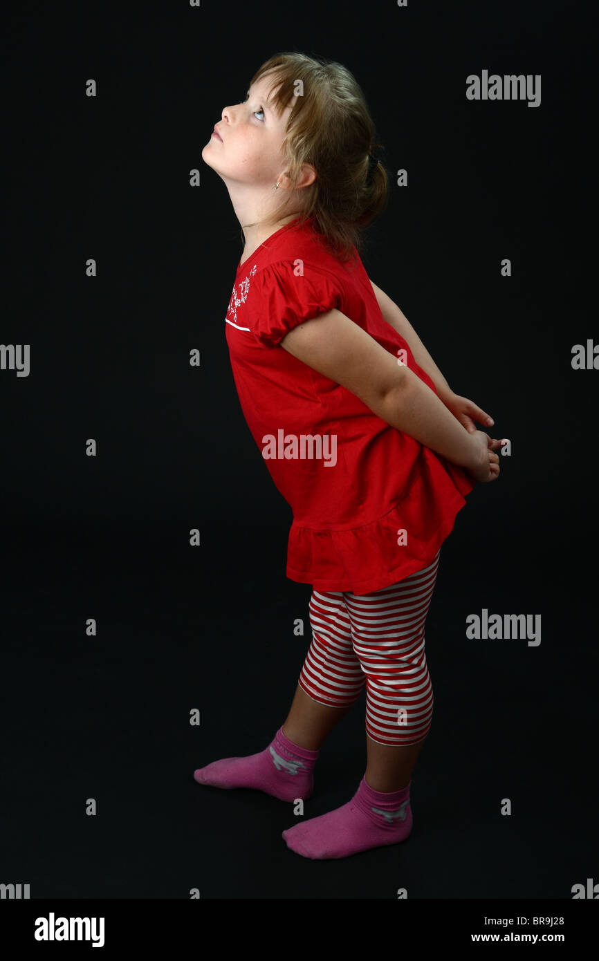 Curious small girl looking up on black Stock Photo - Alamy