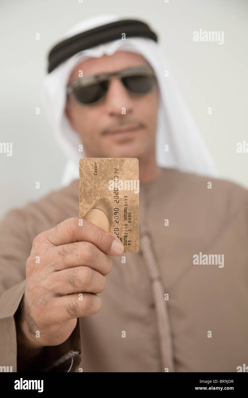 Middle eastern man holding credit card Stock Photo - Alamy