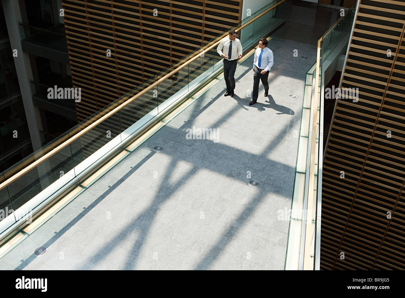 Businessmen on office walkway Stock Photo - Alamy