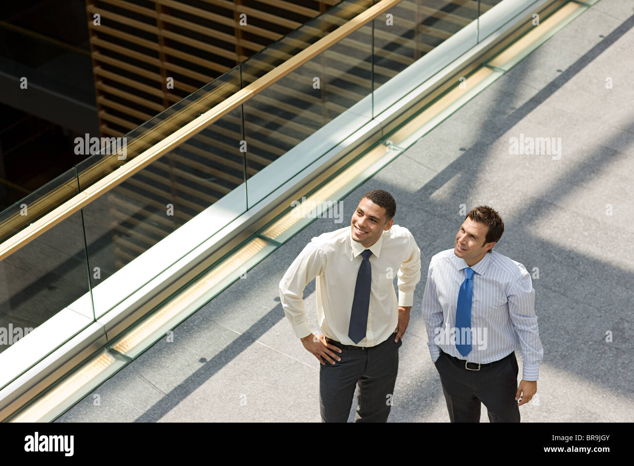 Businessmen on office walkway Stock Photo - Alamy