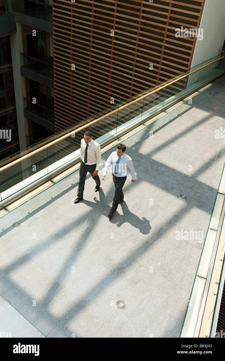 Businessmen walking office walkway Stock Photo - Alamy