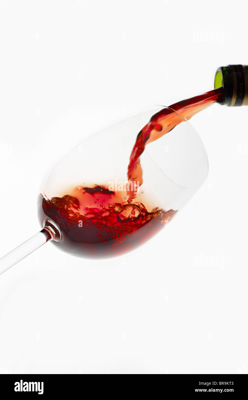 Bottle of red wine being poured into wine glass Stock Photo - Alamy