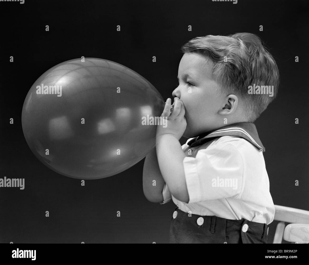 Boy blowing up balloon hi-res stock photography and images - Alamy
