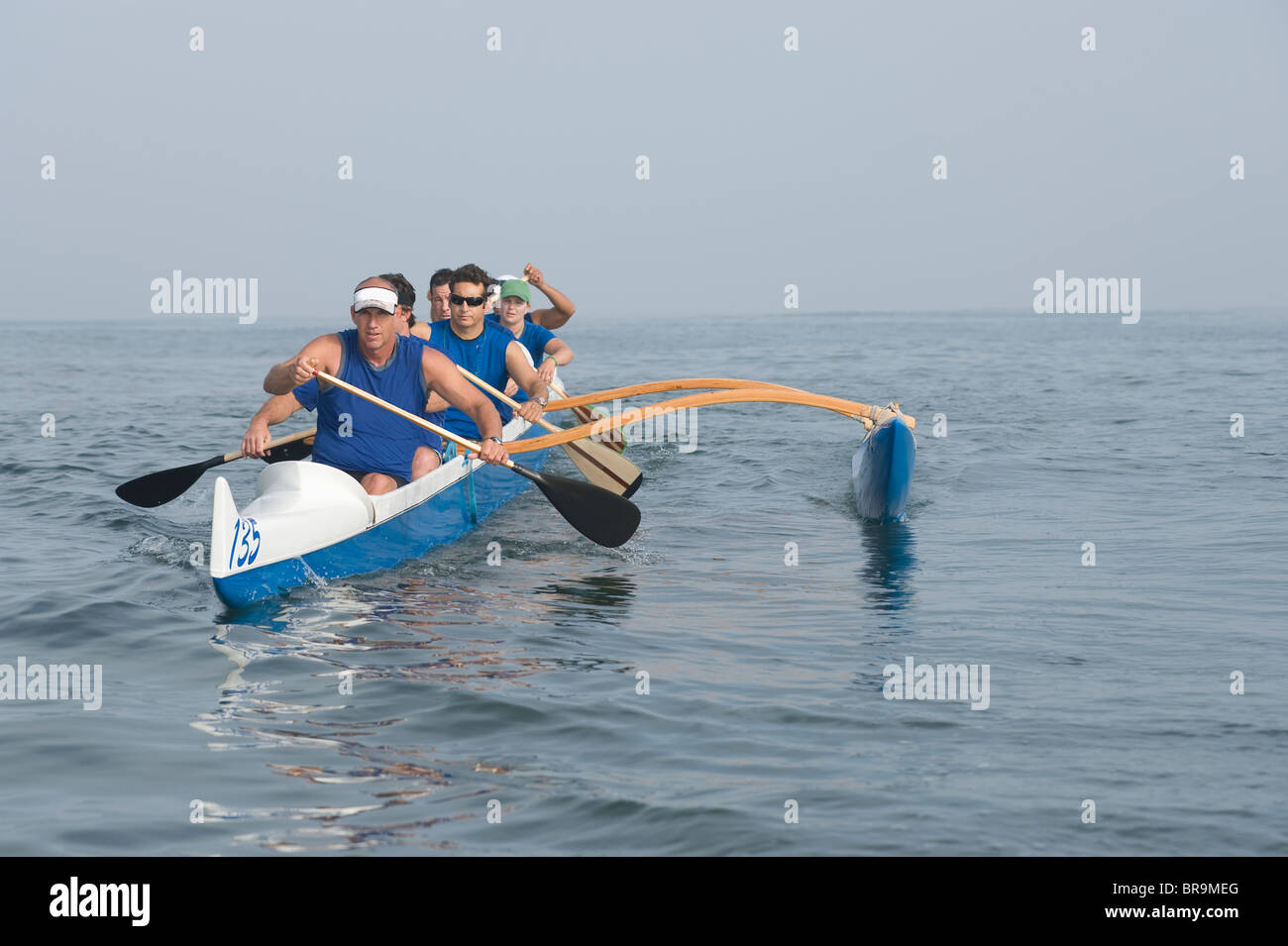 Outrigger canoeing team on water Stock Photo - Alamy