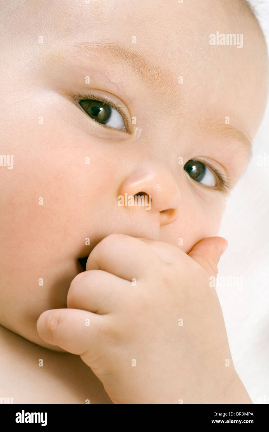 Infant child chewing on hand Stock Photo - Alamy