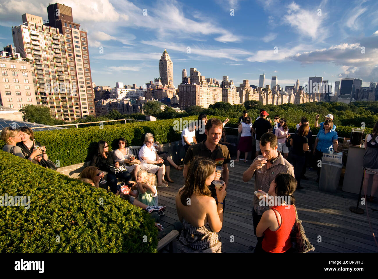 People sip cocktails and take in the views of central park and the city ...