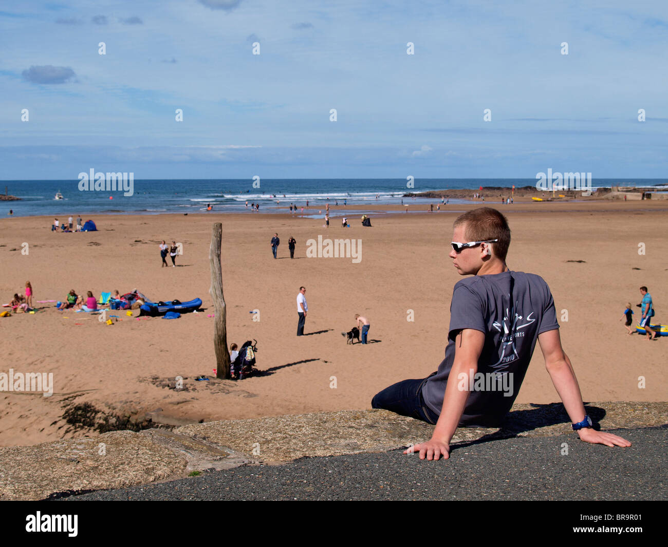 Teenage boy sat looking at the beach, Bude, Cornwall, UK Stock Photo ...