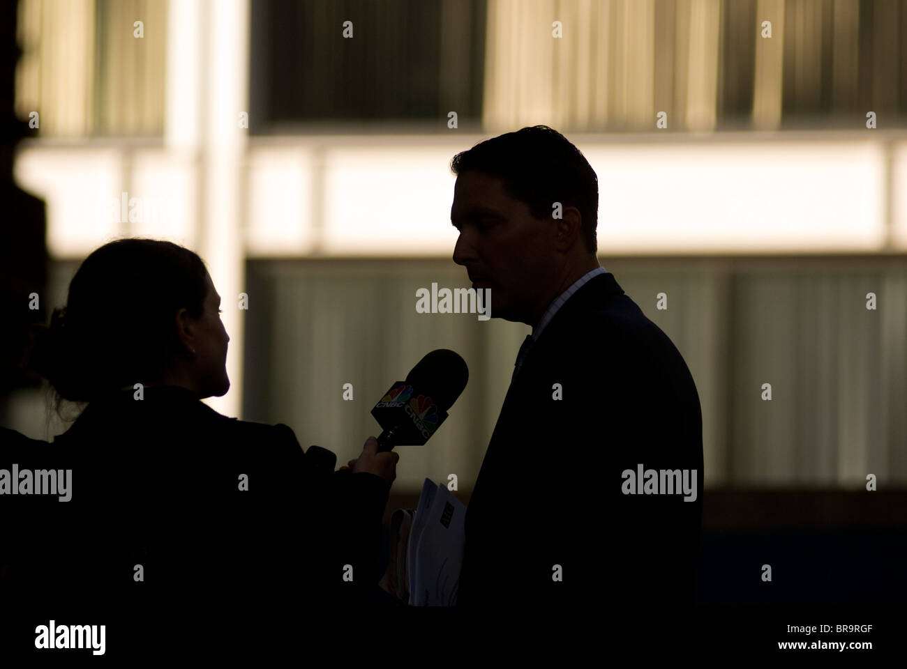A news anchor interviews a man in front of AIG's headquarters in New ...