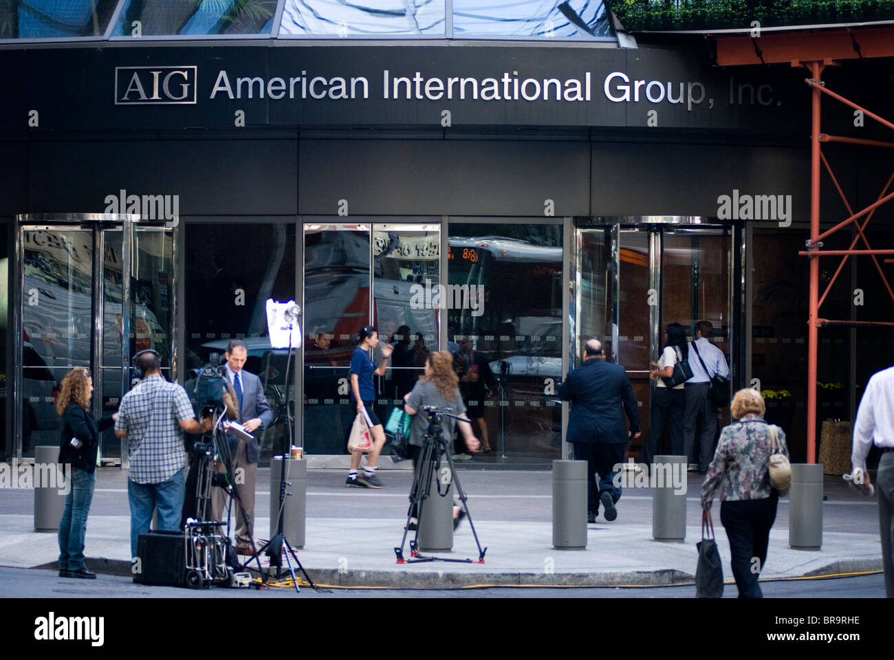 Reporters and employees mill around the entrance to the AIG ...