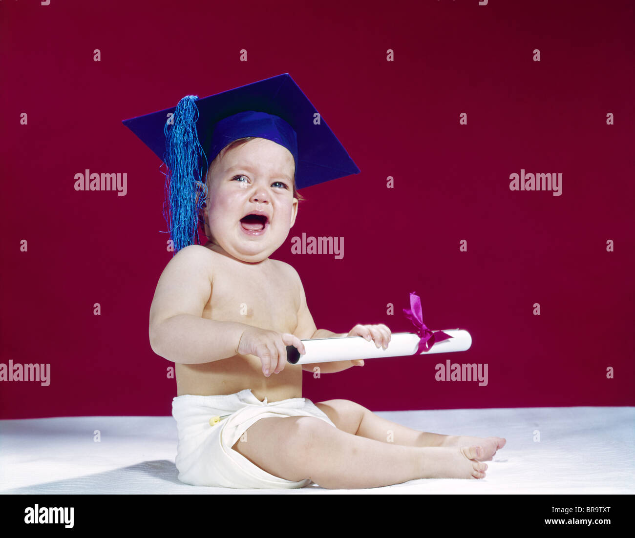 1960s CRYING BABY HOLDING DIPLOMA WEARING GRADUATION CAP Stock Photo ...