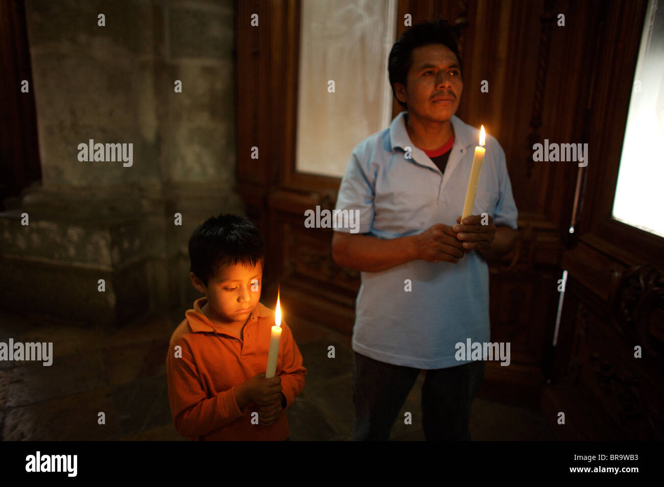 A father and his son hold candles as they pray Stock Photo - Alamy