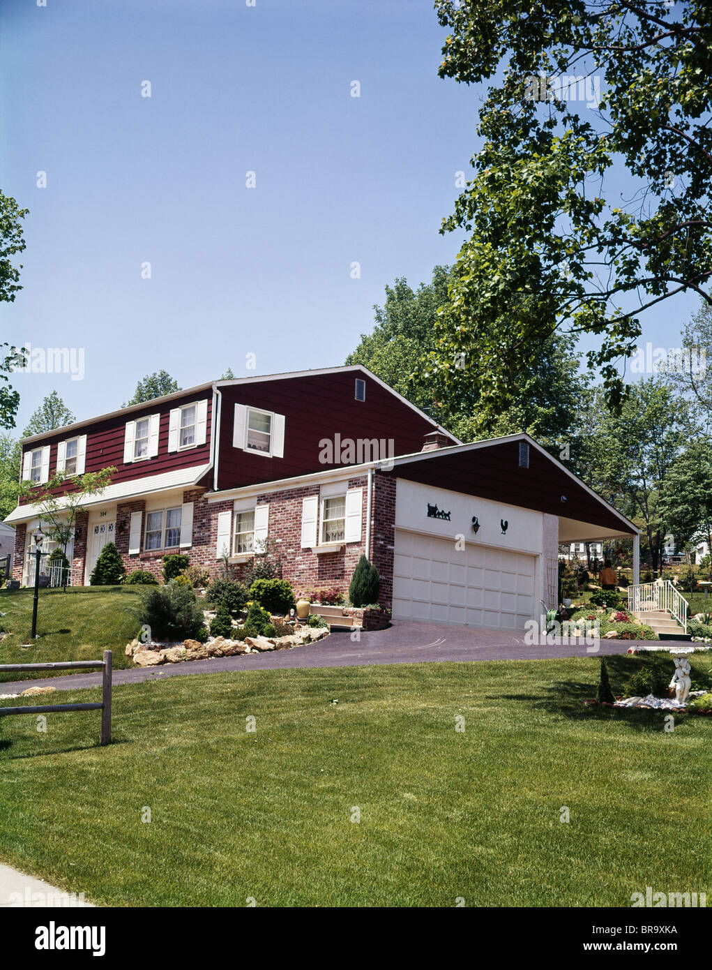 1970s TWO STORY SUBURBAN HOME DRIVEWAY GARAGE LANDSCAPED YARD Stock ...