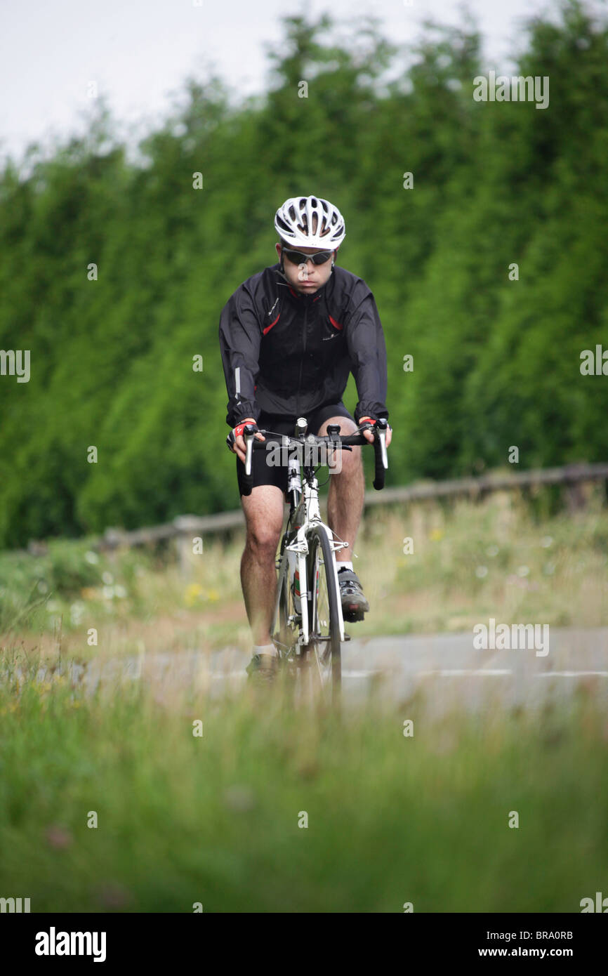 A tired man cycling on the road Stock Photo - Alamy