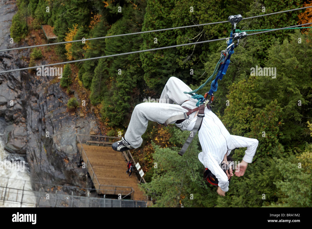 A girl hanging upside down on a zip-line Stock Photo - Alamy