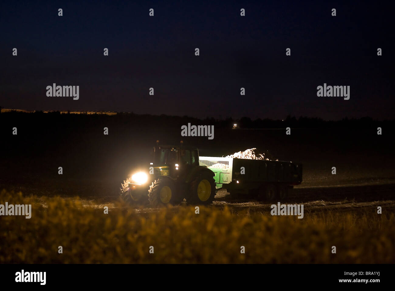 A farmer in Tamworth, Staffordshire, using his tractor during evening ...