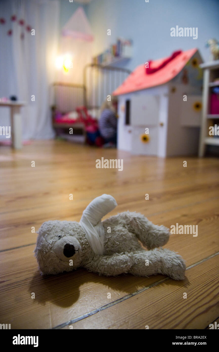 A teddy bear with an injured arm lying on the floor Stock Photo - Alamy