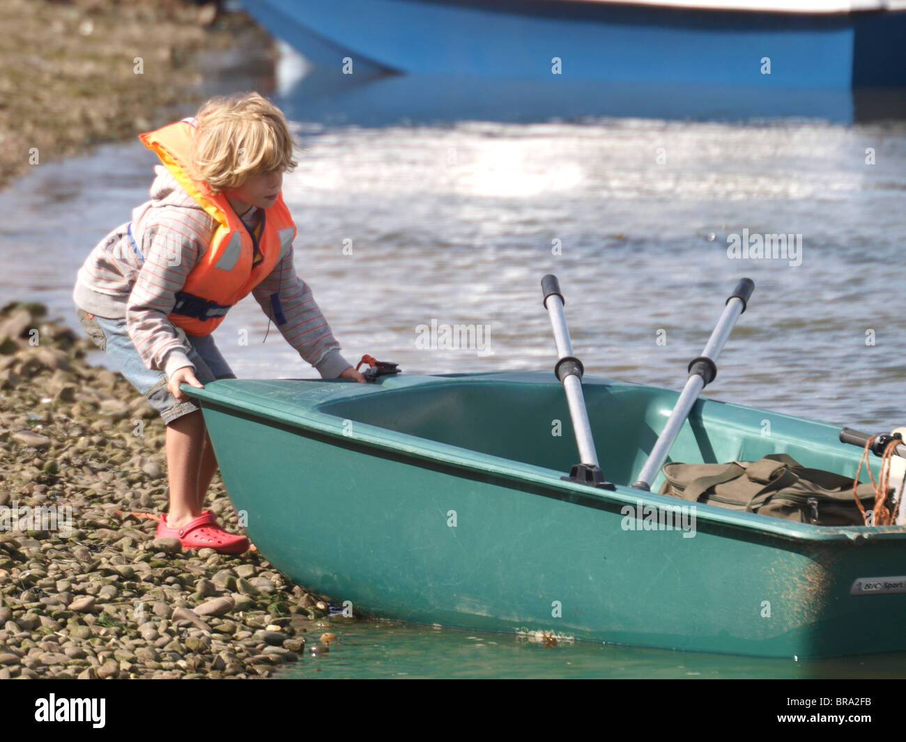 Young child helping to launch a rowing boat, Bude, Cornwall, UK Stock ...