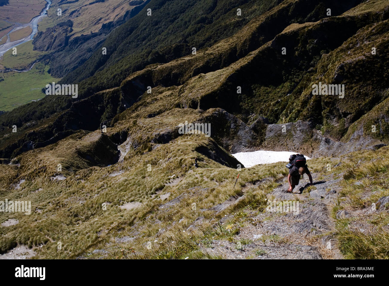 A hiker climbs up from Aspiring Hut towards the Pylon on the Cascade ...
