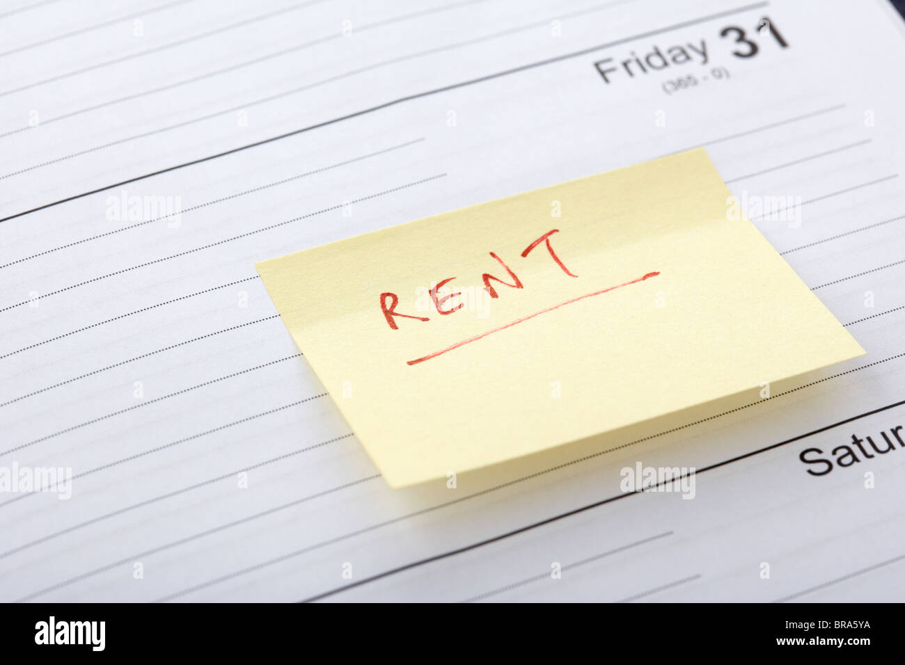 post-it note regarding rent payment due stuck into a diary at the end ...