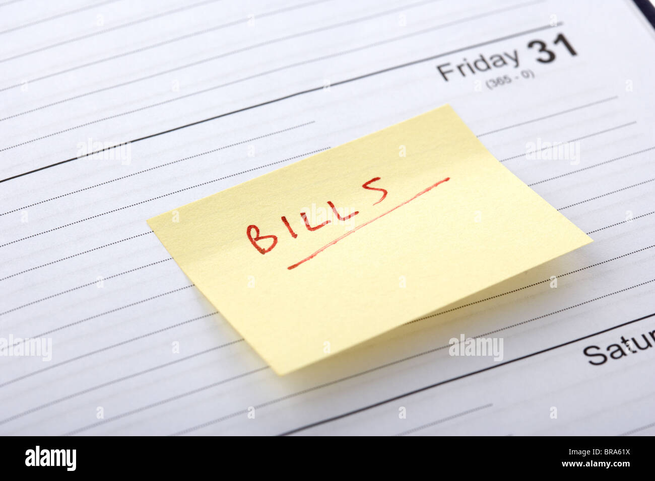 post-it note regarding bills due stuck into a diary at the end of the ...
