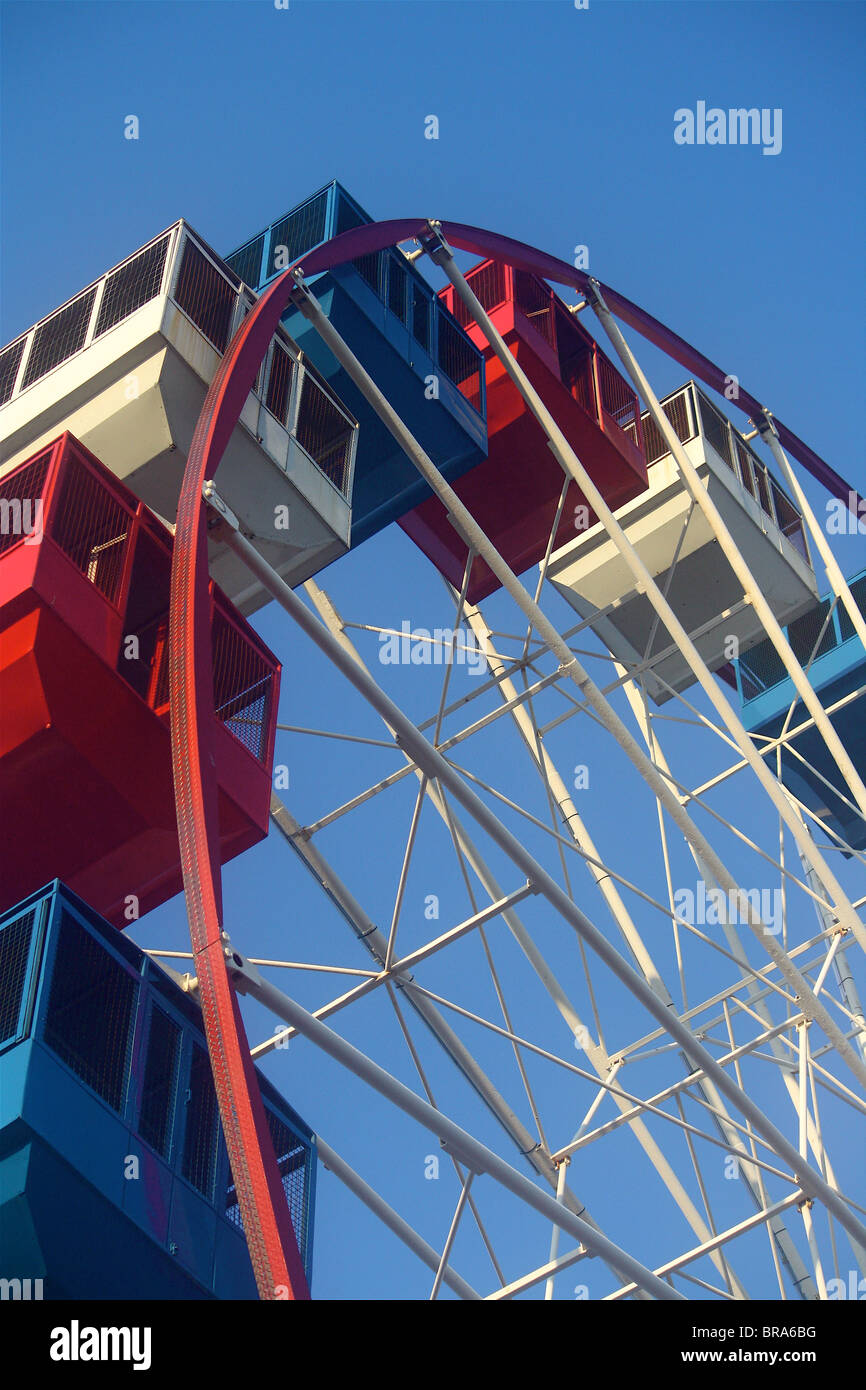 Close up view of red, white, and blue ferris wheel cars with a blue sky ...