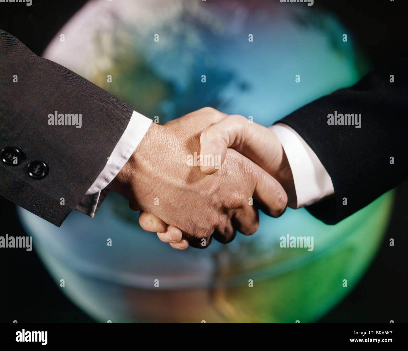 1960s MALE HANDSHAKE IN FRONT OF WORLD GLOBE Stock Photo - Alamy