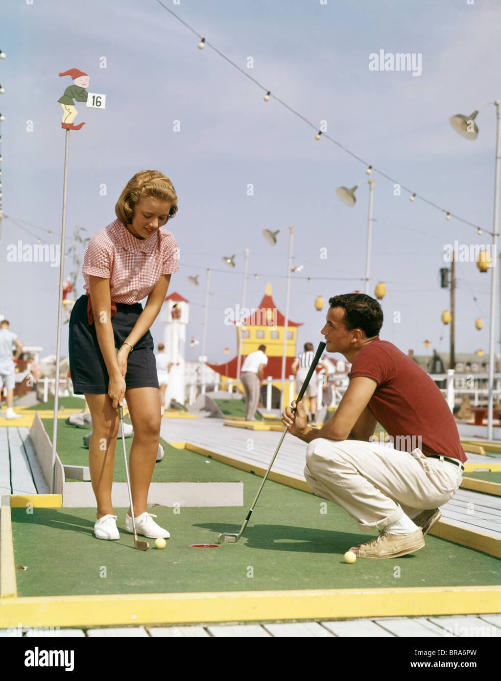 1950s 1960s YOUNG COUPLE MAN WOMAN PLAY MINIATURE GOLF SUMMER AMUSEMENT ...