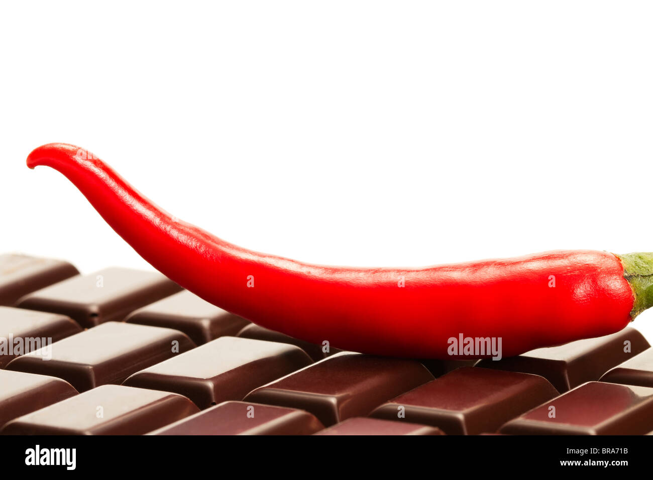red chili on a plain chocolate bar on white background Stock Photo - Alamy