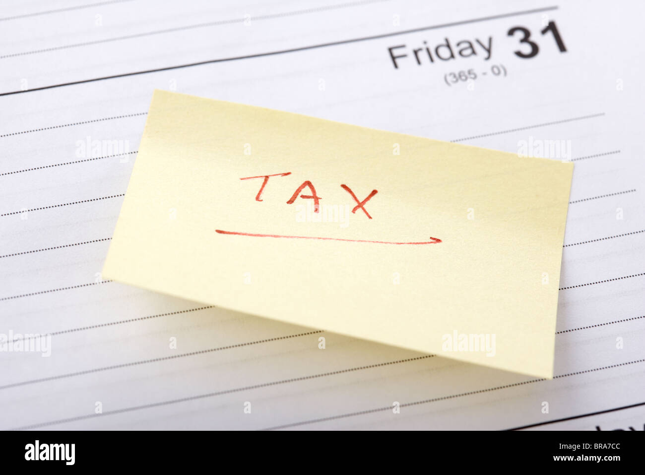 post-it note regarding tax bill reminder stuck into a diary at the end ...