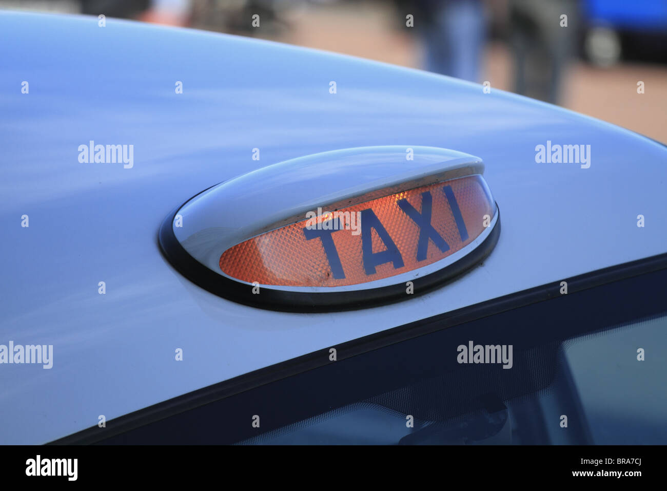 An illuminated TAXI sign on the roof of a cab Stock Photo - Alamy