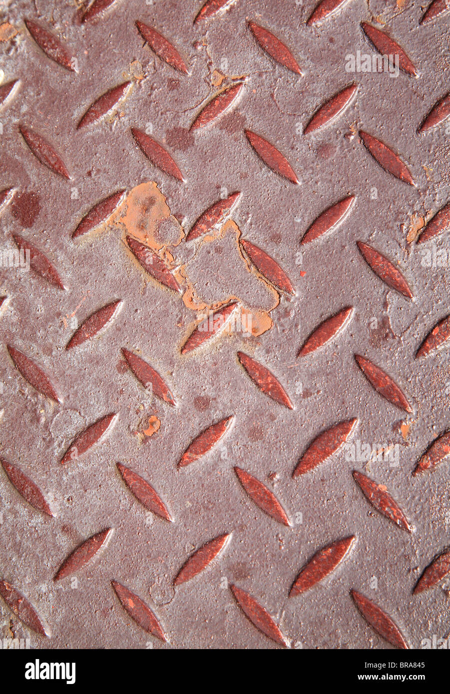 background texture of a red steel metal grate with patterned ridges ...
