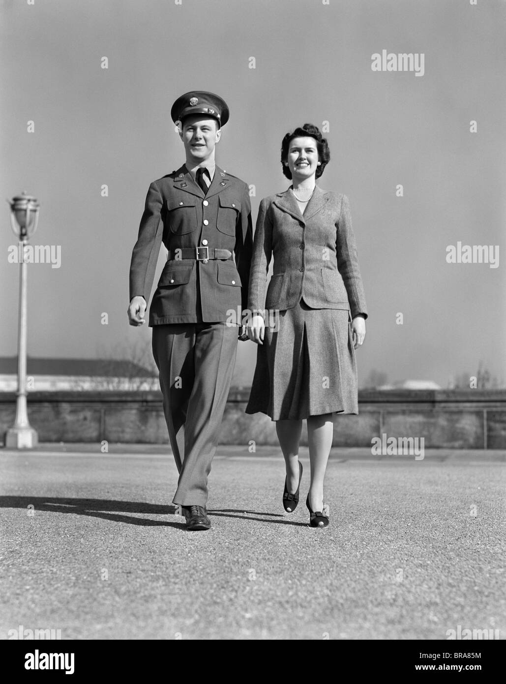1940s SMILING COUPLE WALKING FORWARD MAN IN ARMY UNIFORM Stock Photo ...