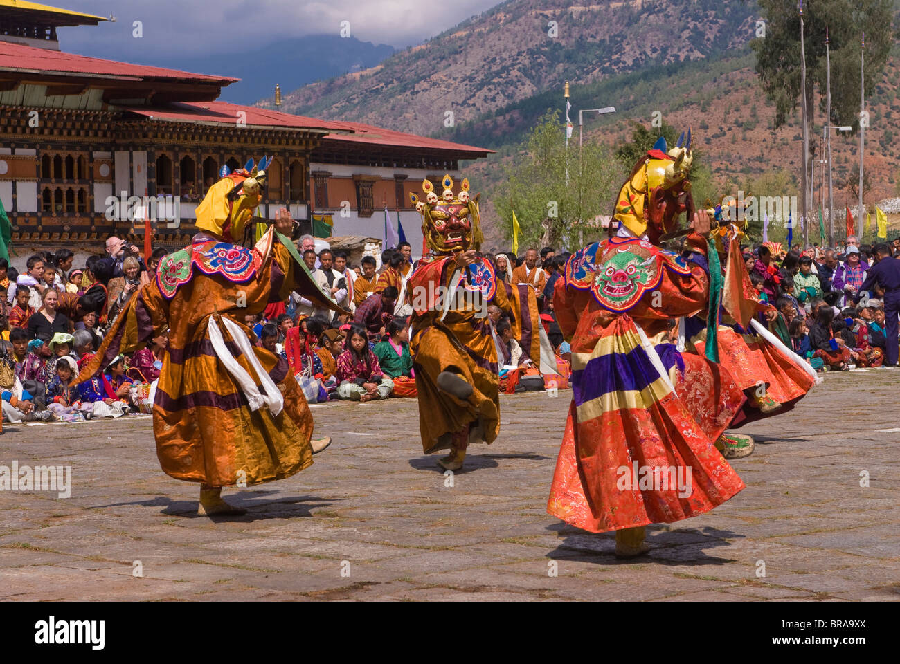 Costumed dancers at religious festival with many visitors, Paro Tsechu ...
