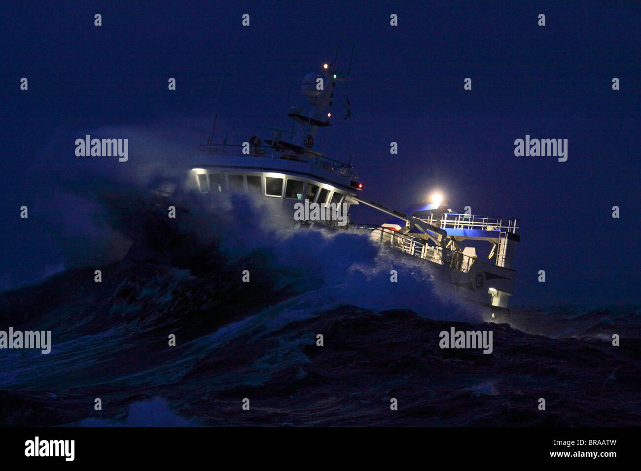 Fishing vessel trawling on a winter night in the North Sea. December ...